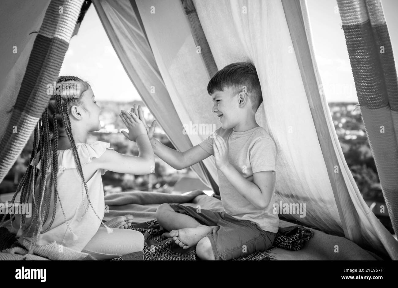 Brother and sister playing together. Happy kids family playing in tent ...