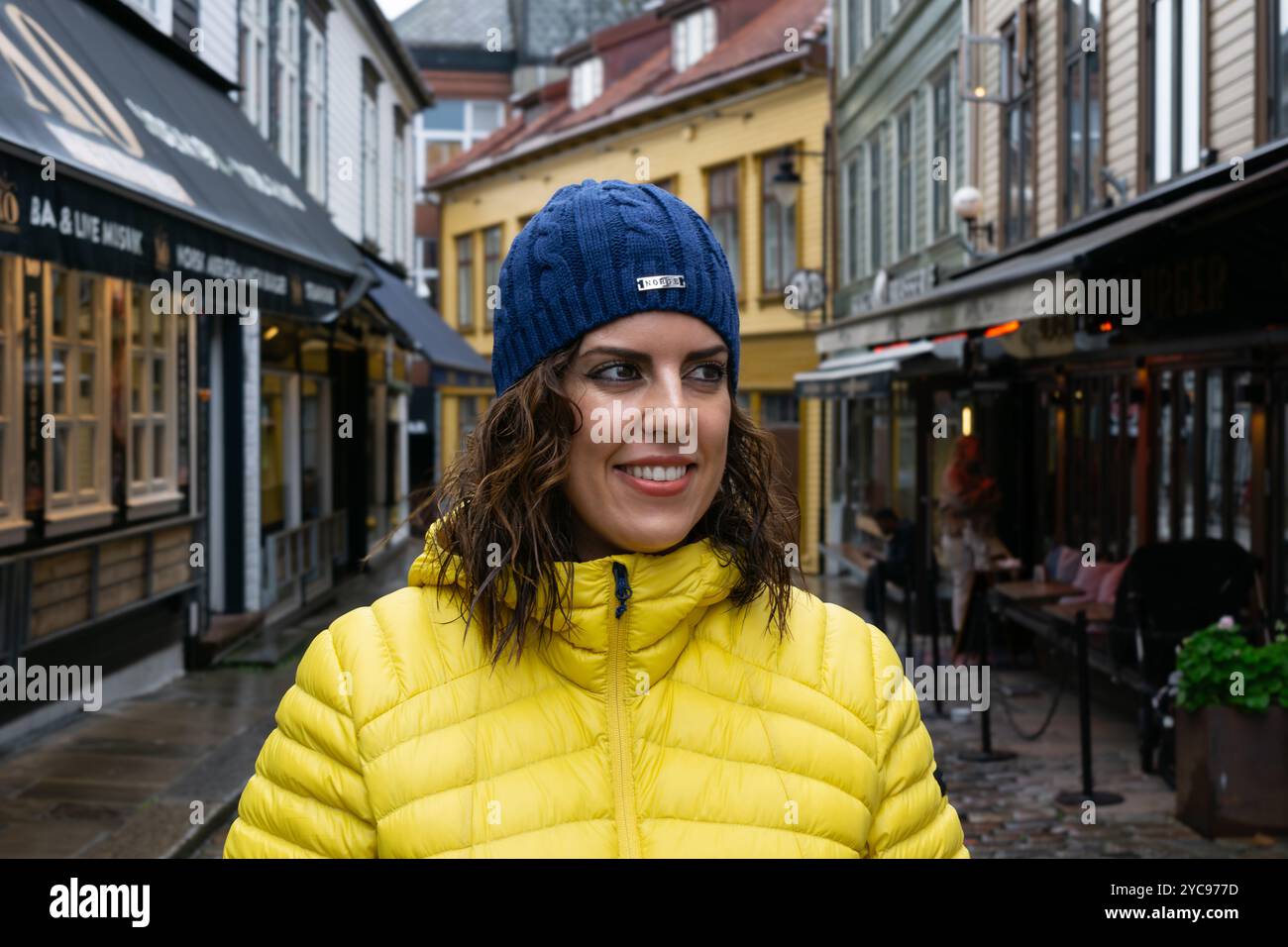 A young brunette woman, around 30 years old, wearing a yellow anorak ...