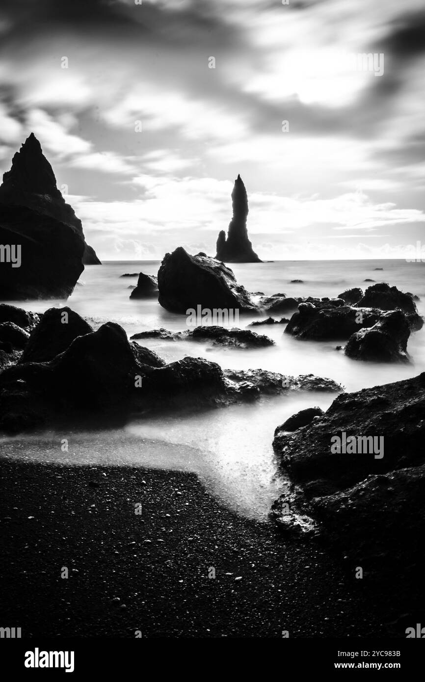 Dramatic coastal scene in black and white, rocks in the calm sea, Vik ...