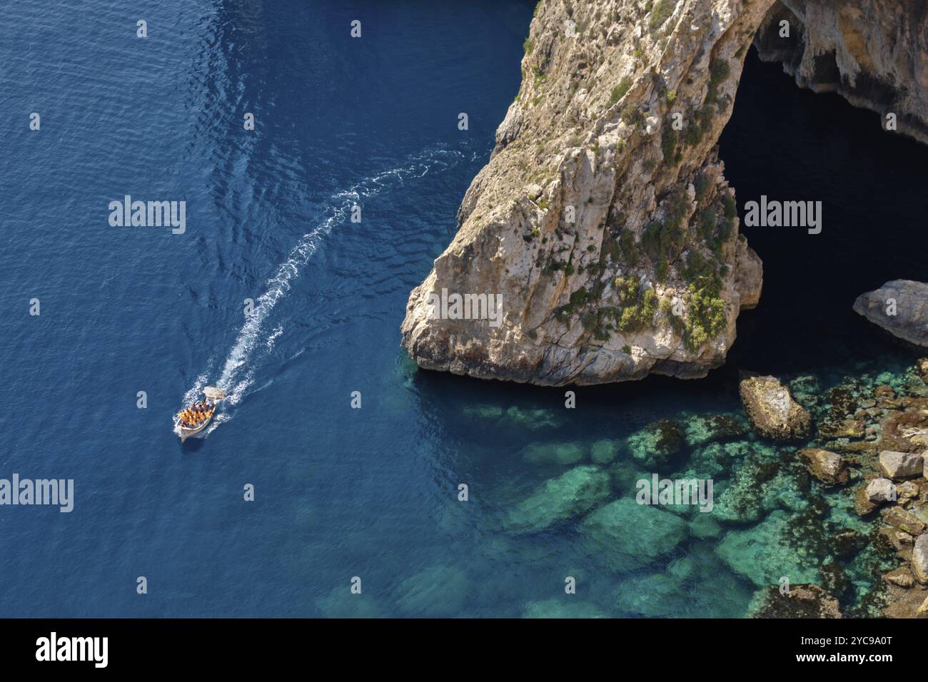 A tourist boat at the Blue Grotto photographed from the Blue Wall and ...