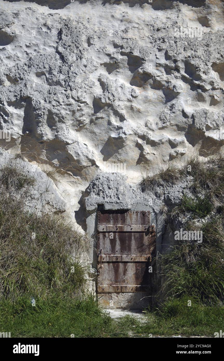 Old iron door set in a cliff face, Dunedin, South Island, New Zealand ...