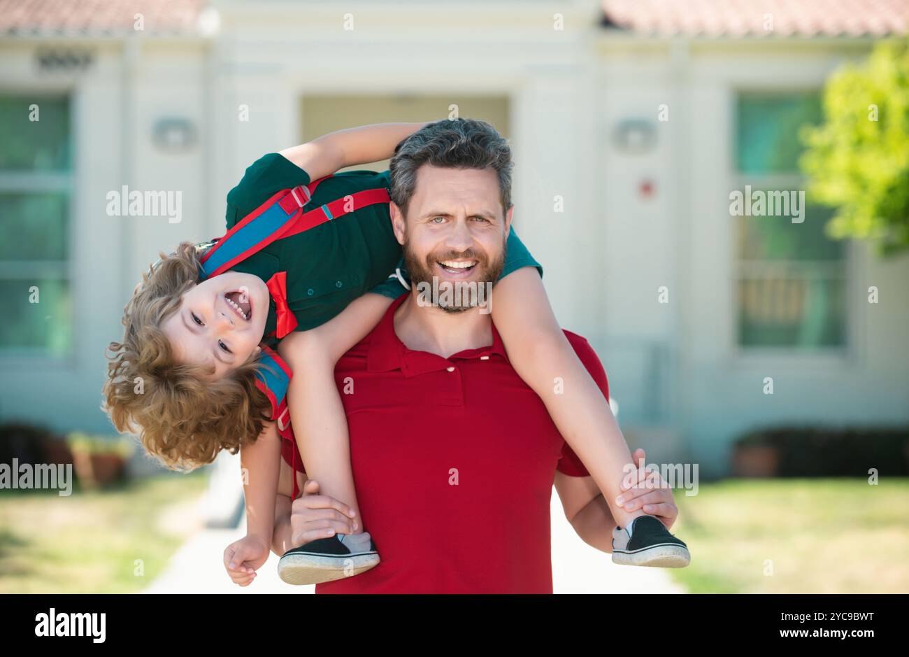 Parent supports and motivates son. Father giving son piggyback ride ...
