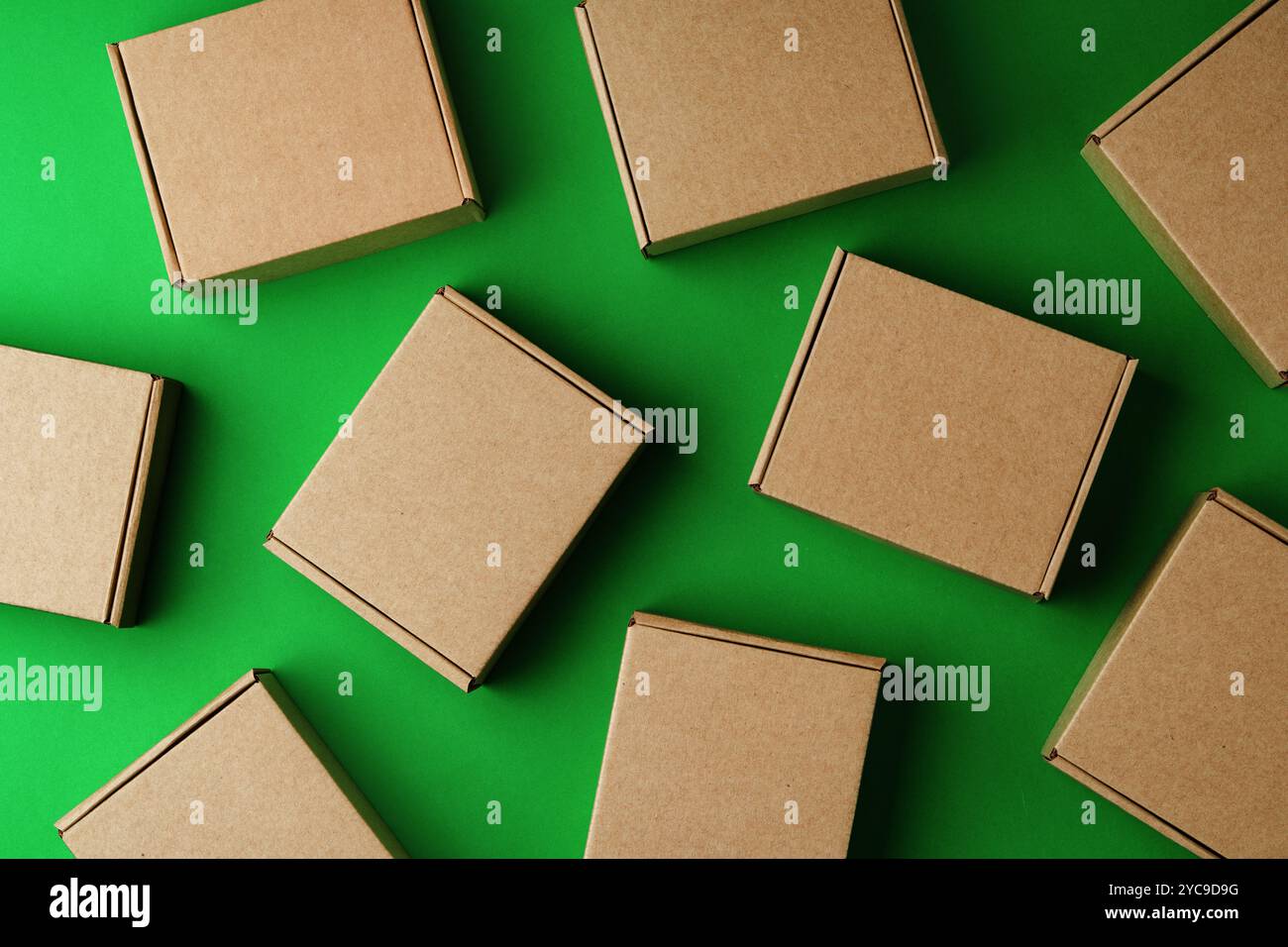 Brown cardboard boxes arranged on a vibrant green surface Stock Photo ...