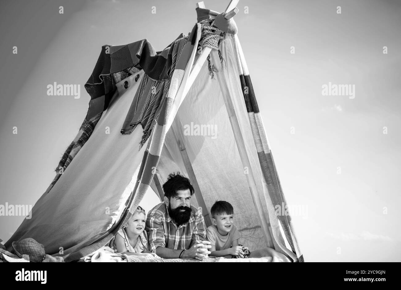 Dad with kids playing together in tent. Summer outdoor. Family playing ...