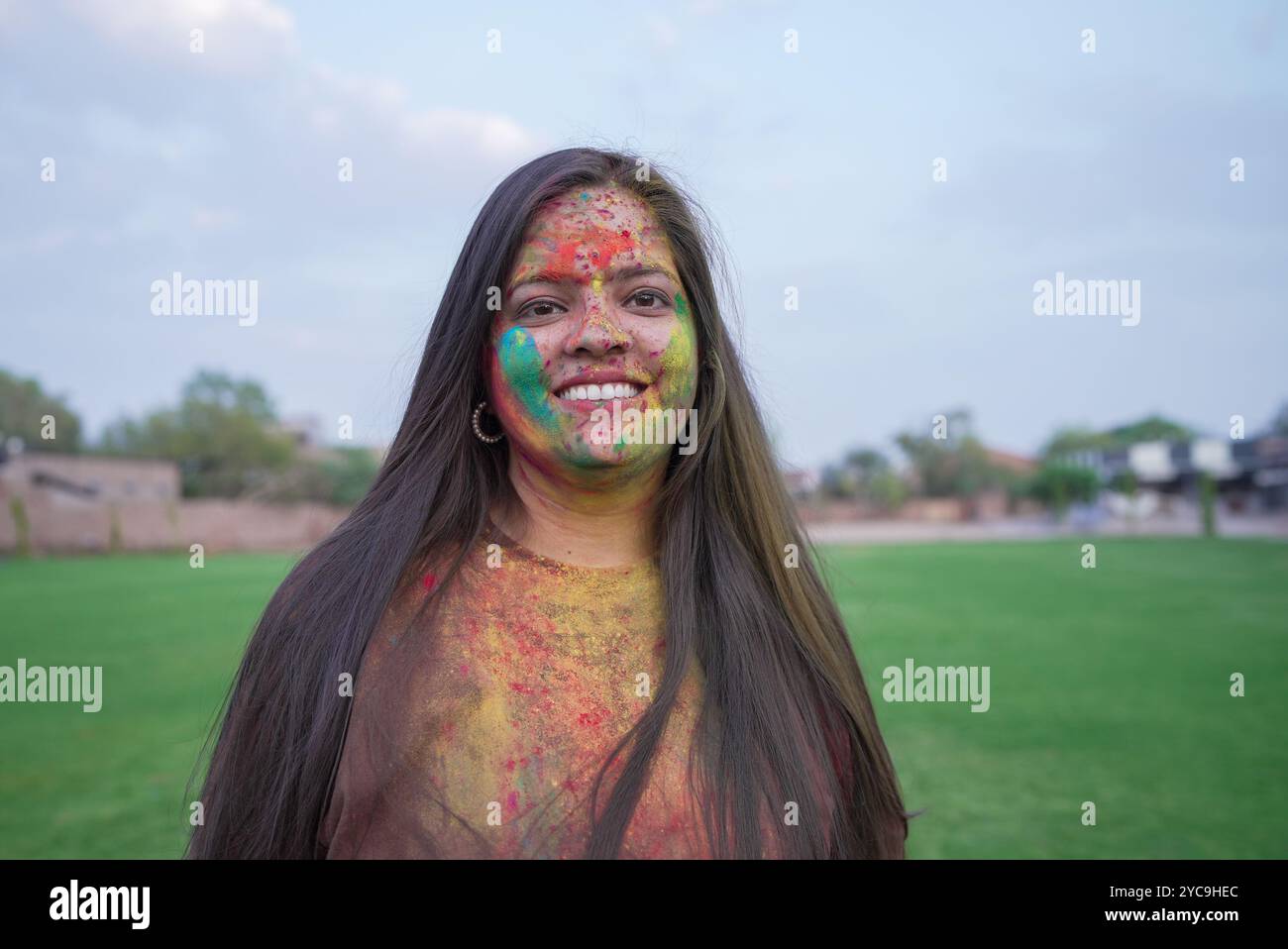 Happy young indian woman covered with colorful powder or gulal ...