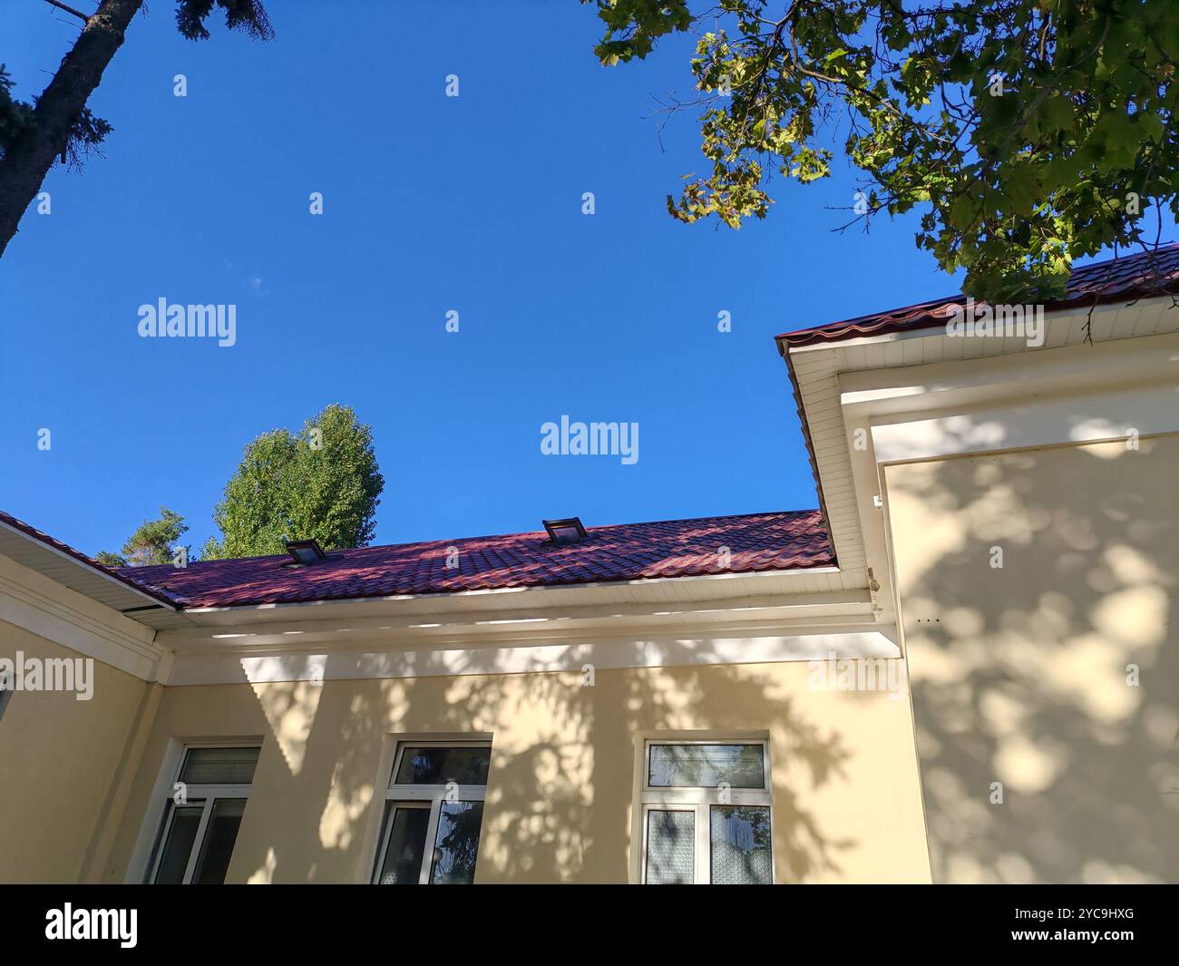 A traditional building with red accents and a tall, sloped roof, framed ...