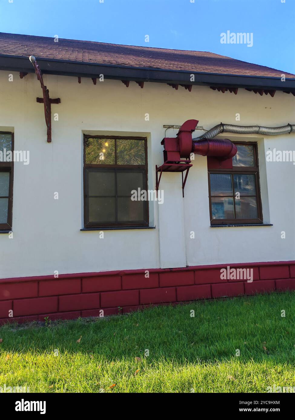 historic building with red brick columns and a sloping roof, nestled ...