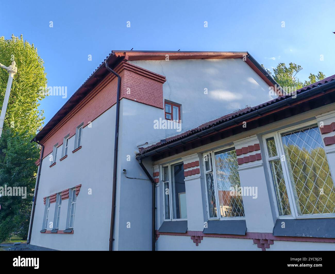 historic building with red brick columns and a sloping roof, nestled ...
