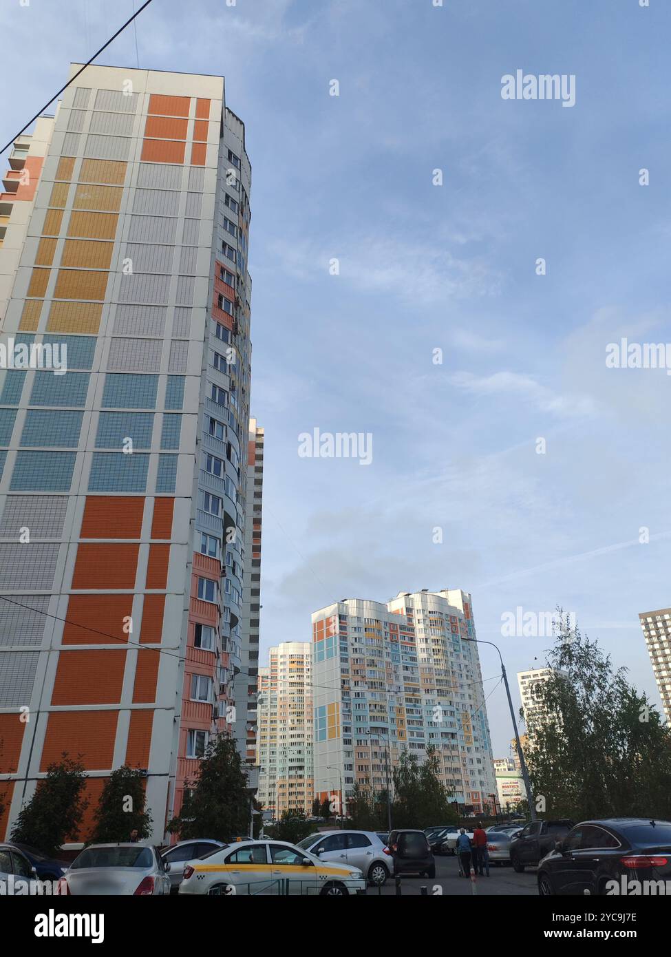 A large multi-story residential building with a pastel color palette of ...