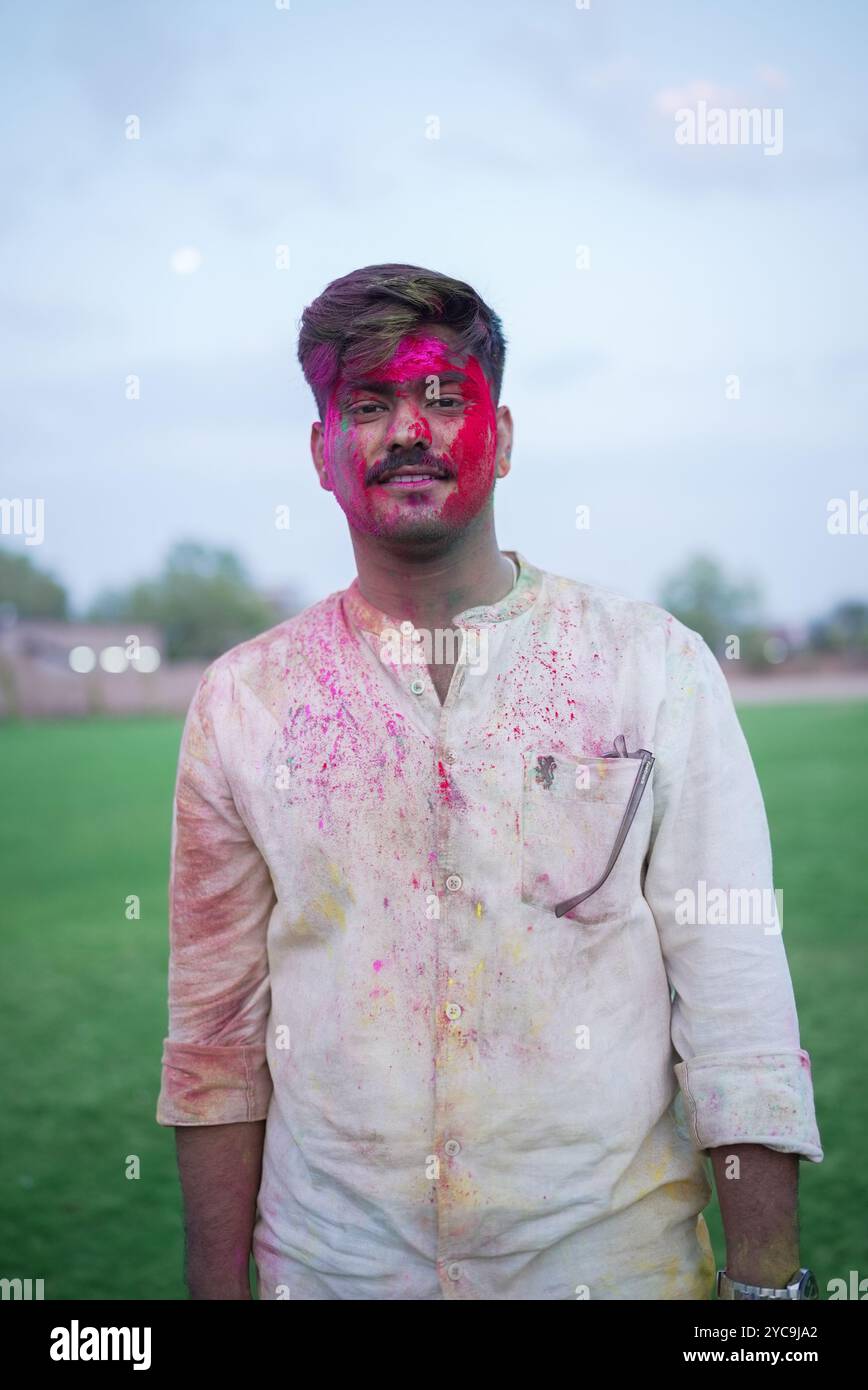 Portrait of Happy young indian man covered with colorful powder or ...