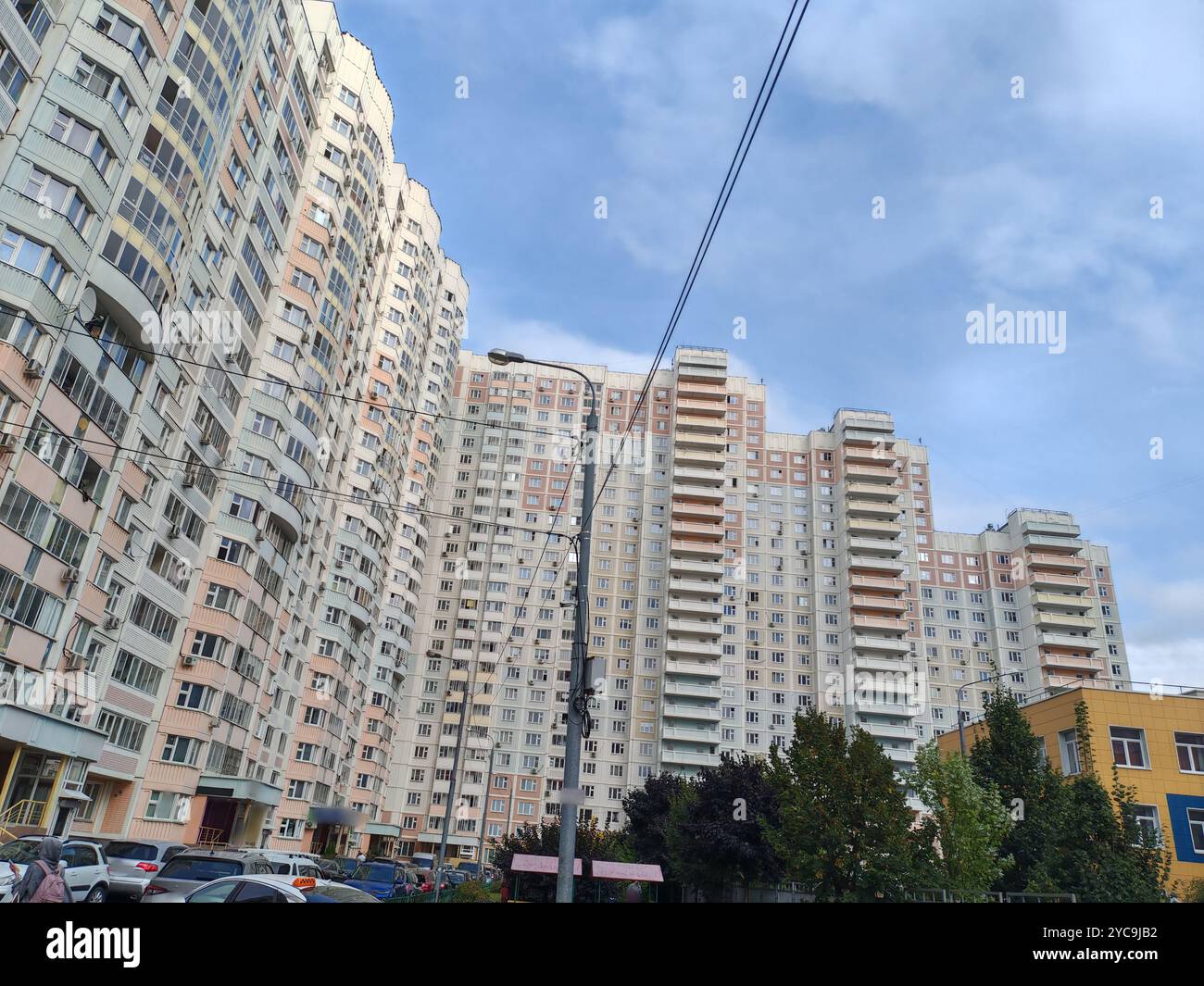 A tall apartment building with pastel-colored balconies and windows ...