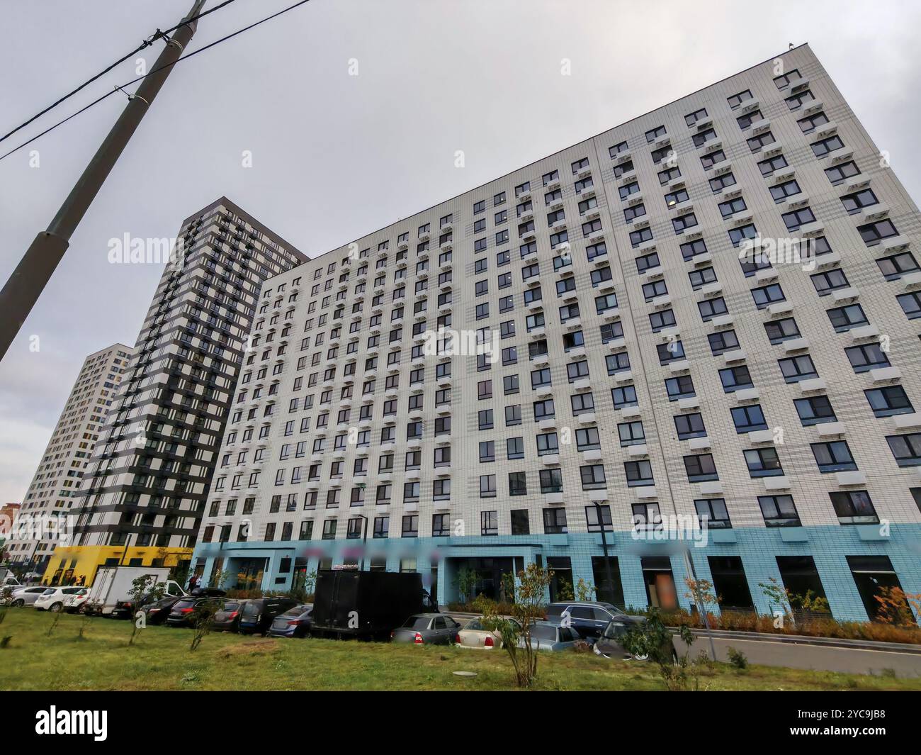 A pastel-colored high-rise residential building with curved balconies ...