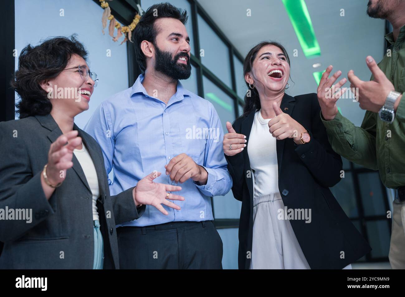 group of young indian business people celebrating project success at ...