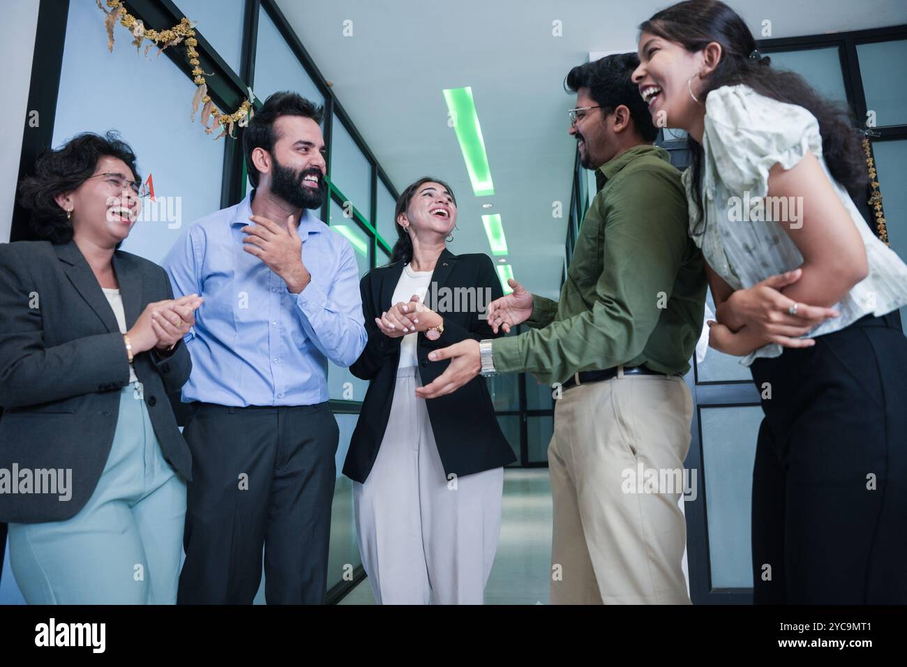 happy group of young indian company employees enjoying after successful meeting at office. team ...