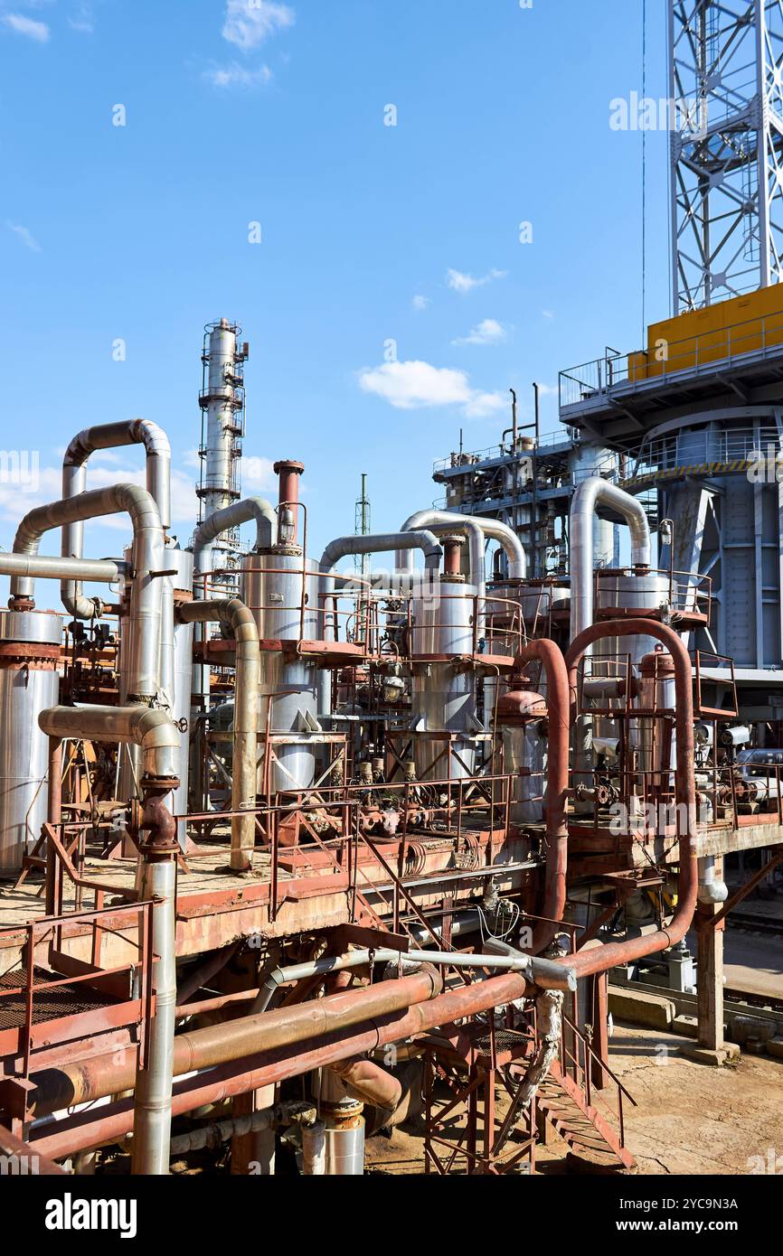 Old distillation column towers and reactors under blue evening sky ...