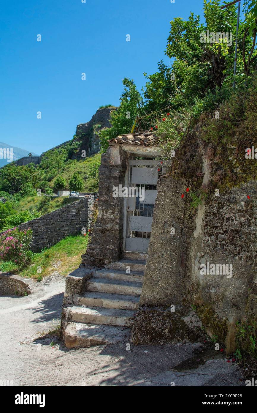 An old metal garden gate in a traditional stone wall in Gjirokaster ...
