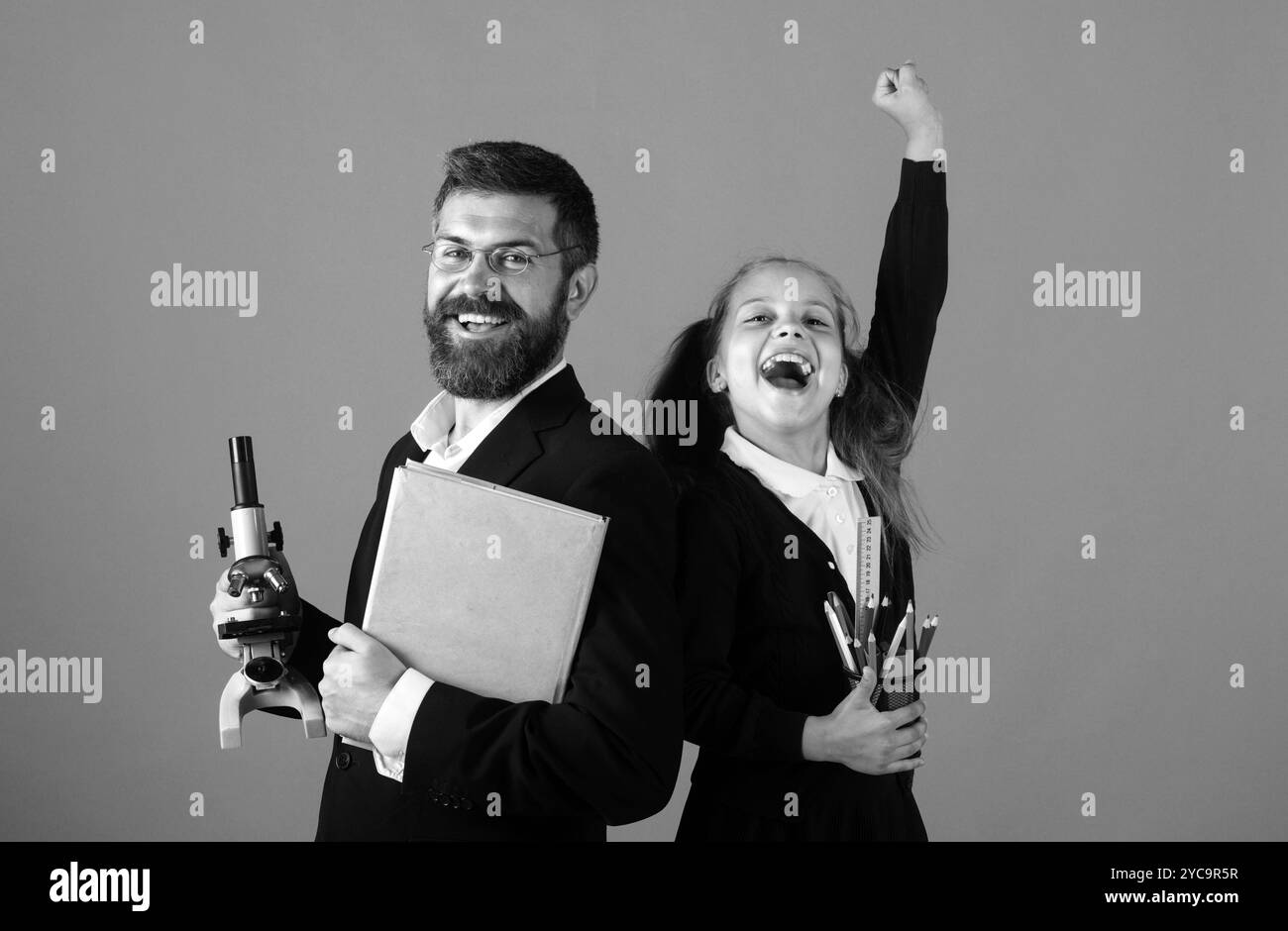 Cheerful smiling little girl in school uniform having fun in studio ...