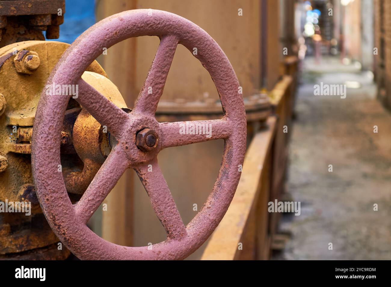 Rusty weathered valve handwheel closeup shot over industrial ...