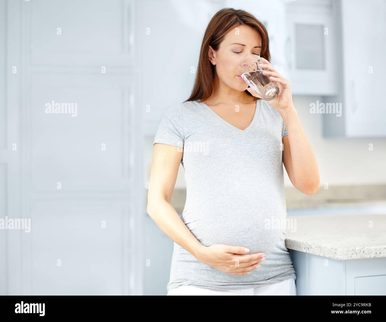 Pregnant woman, morning and drinking water in home, nutrition and aqua ...