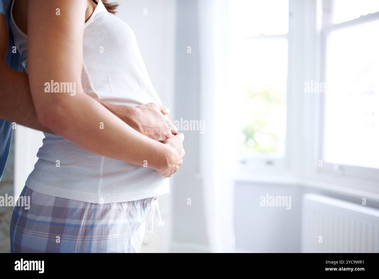 Couple, embrace and pregnancy with stomach, hands and bonding in home ...