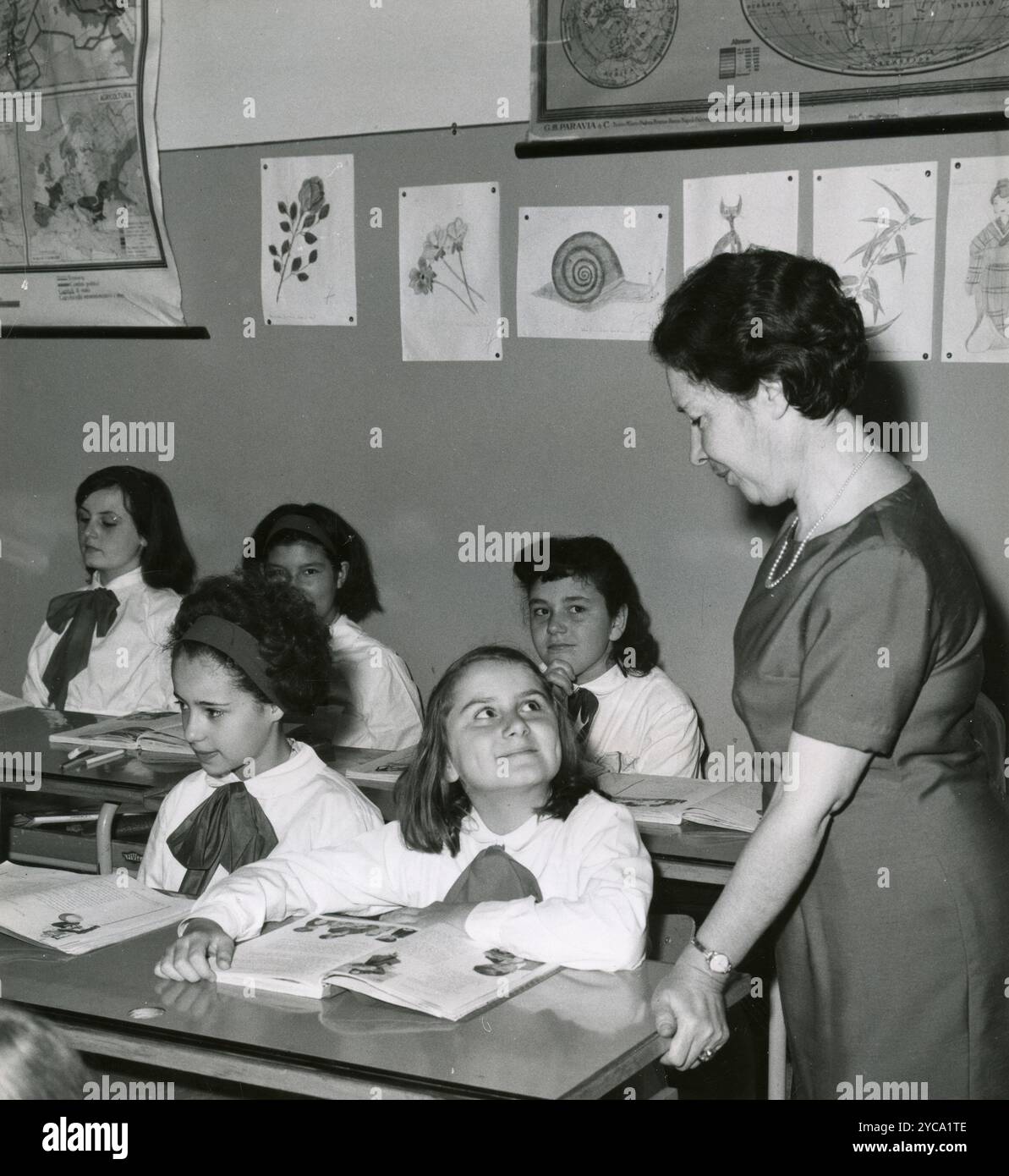 The teacher smiles at her pupil in the classroom, Italy 1960s Stock ...