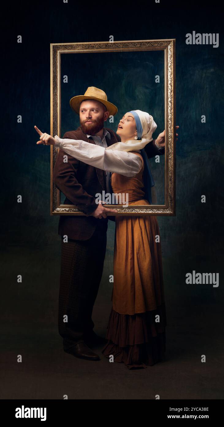 Couple, dressed in retro clothing, posing within golden frame against ...