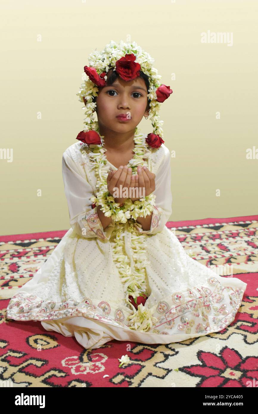 Portrait of an Indian Muslim five-year-old girl, raising her hands in ...