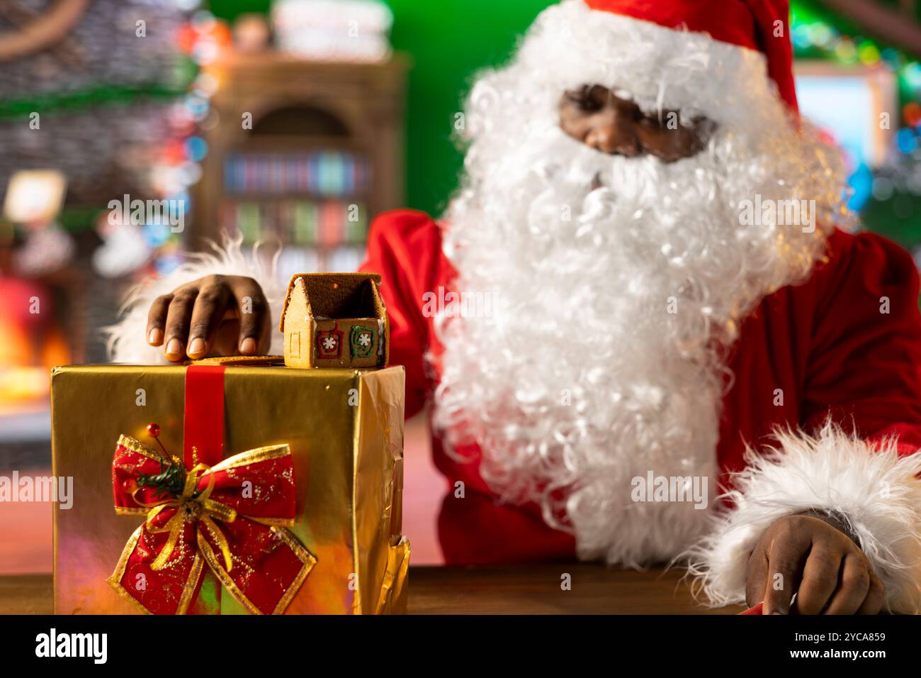 Santa Claus decorates gingerbread cookies with multicolored icing in a ...