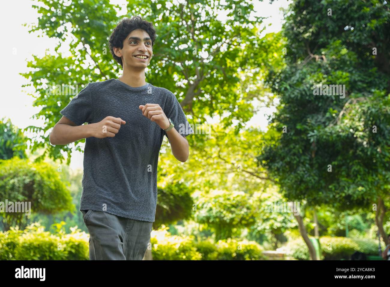 Young Indian Gen Z Boy Running At Summer Park Outdoor Fitness And
