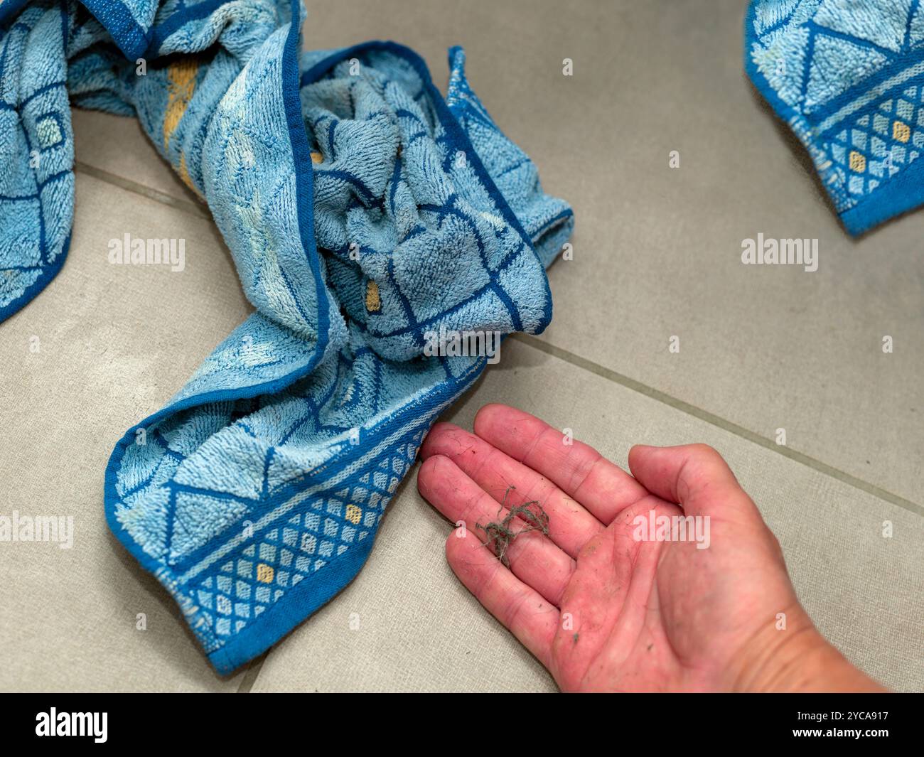 hair and dust on a hand and tiled floor with bathroom towels Stock ...