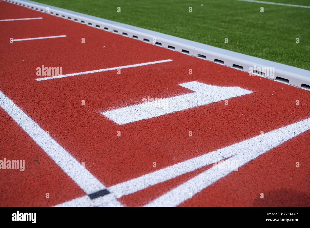 The brightly colored red running track features a clearly marked lane ...