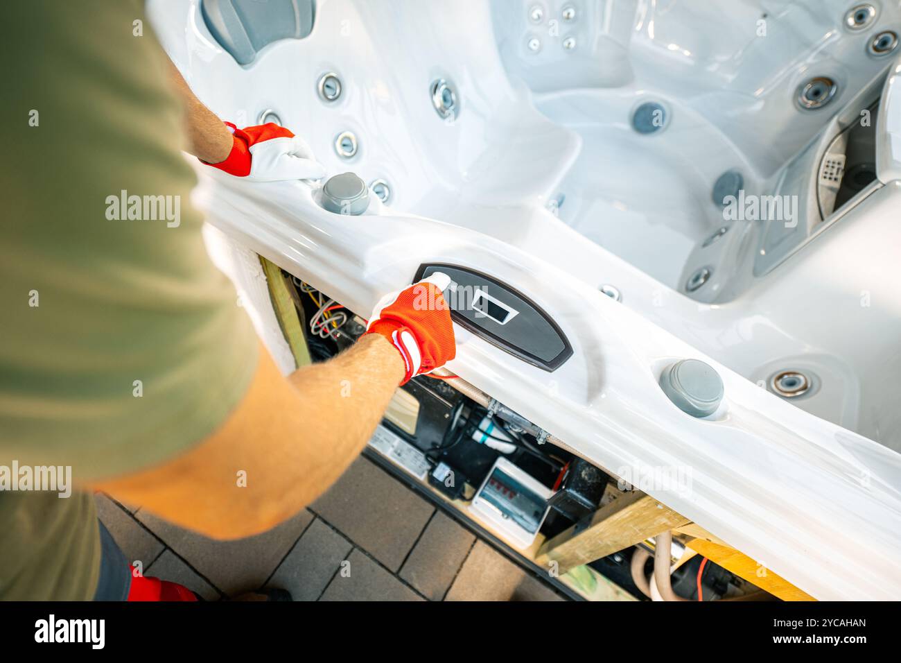 A technician in gloves is adjusting the control panel of a hot tub ...