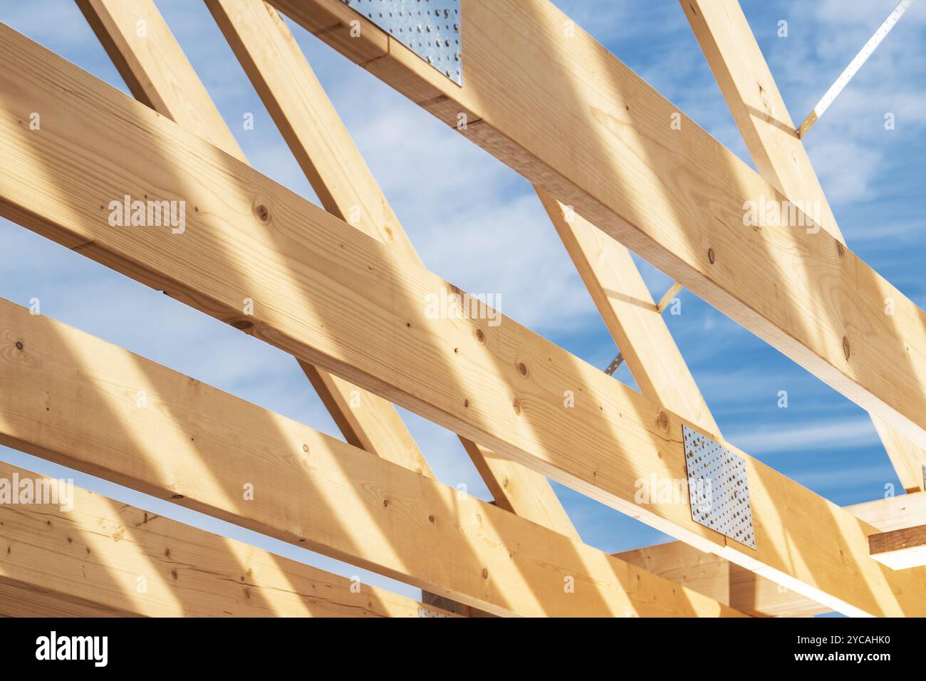 A wooden framework is being constructed with beams and metal connectors ...