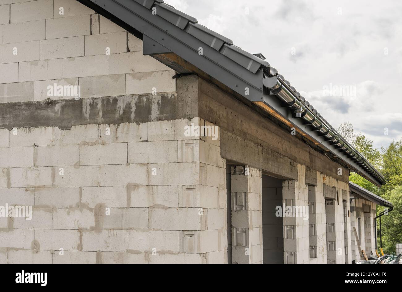 The structure features an unfinished exterior made of concrete blocks ...