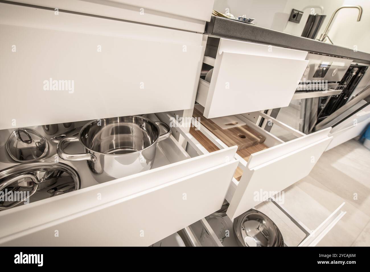 The kitchen features neatly organized cooking pots and utensils in open ...