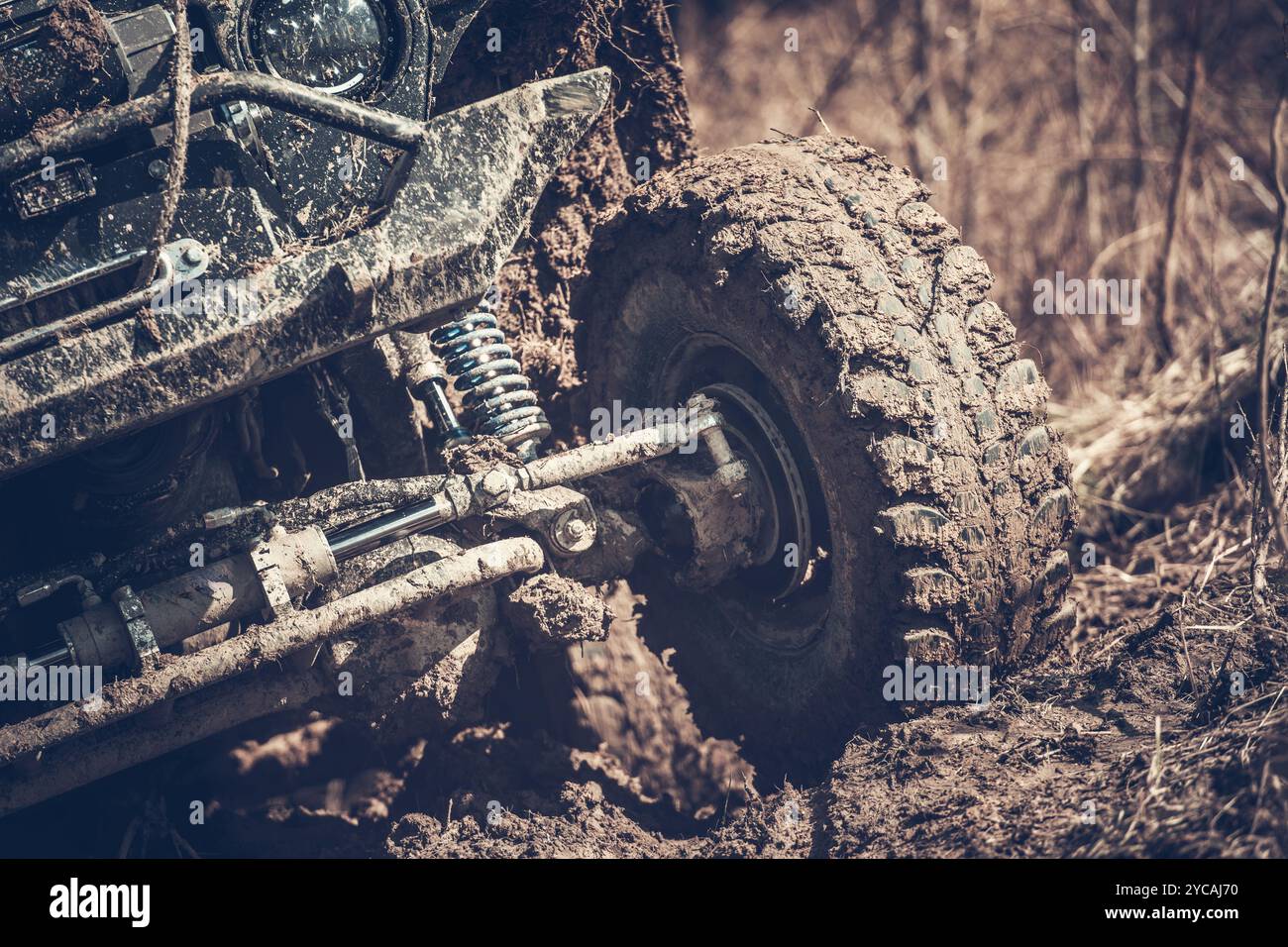 A rugged off-road vehicle struggles through thick mud, emphasizing its ...
