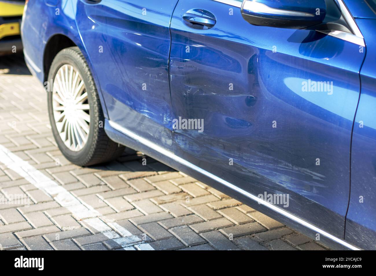 A blue car, which is a type of land vehicle, is currently parked on a ...