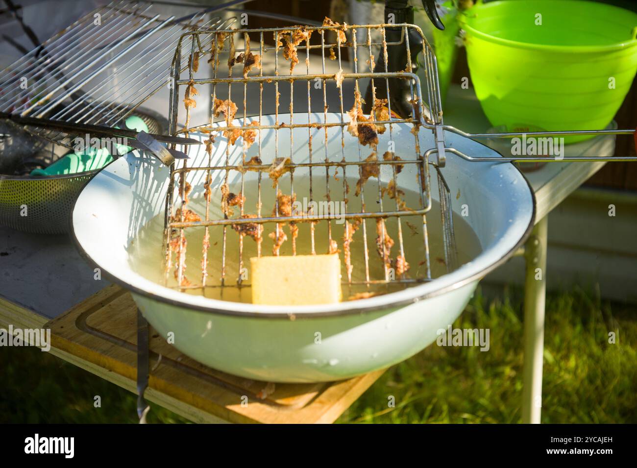 dirty barbecue grill grate with stinky meat abandoned in basin, outdoor ...