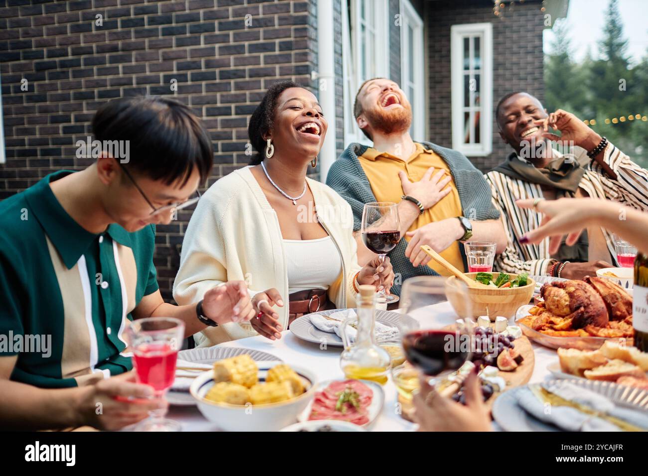 Candid image of multiethnic group of adult friends laughing happily ...