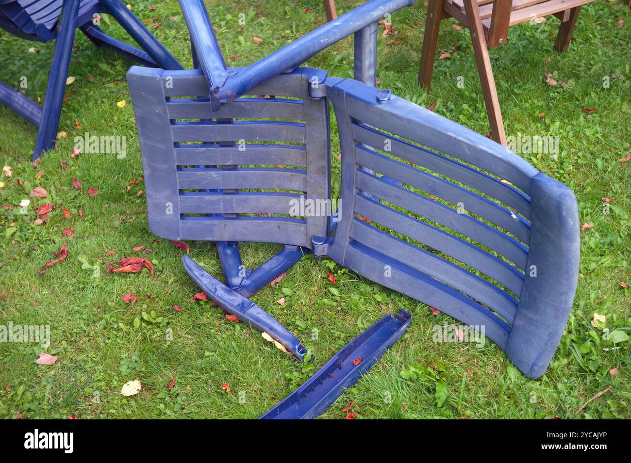 a plastic garden chair with broken leg abandoned on the lawn Stock ...