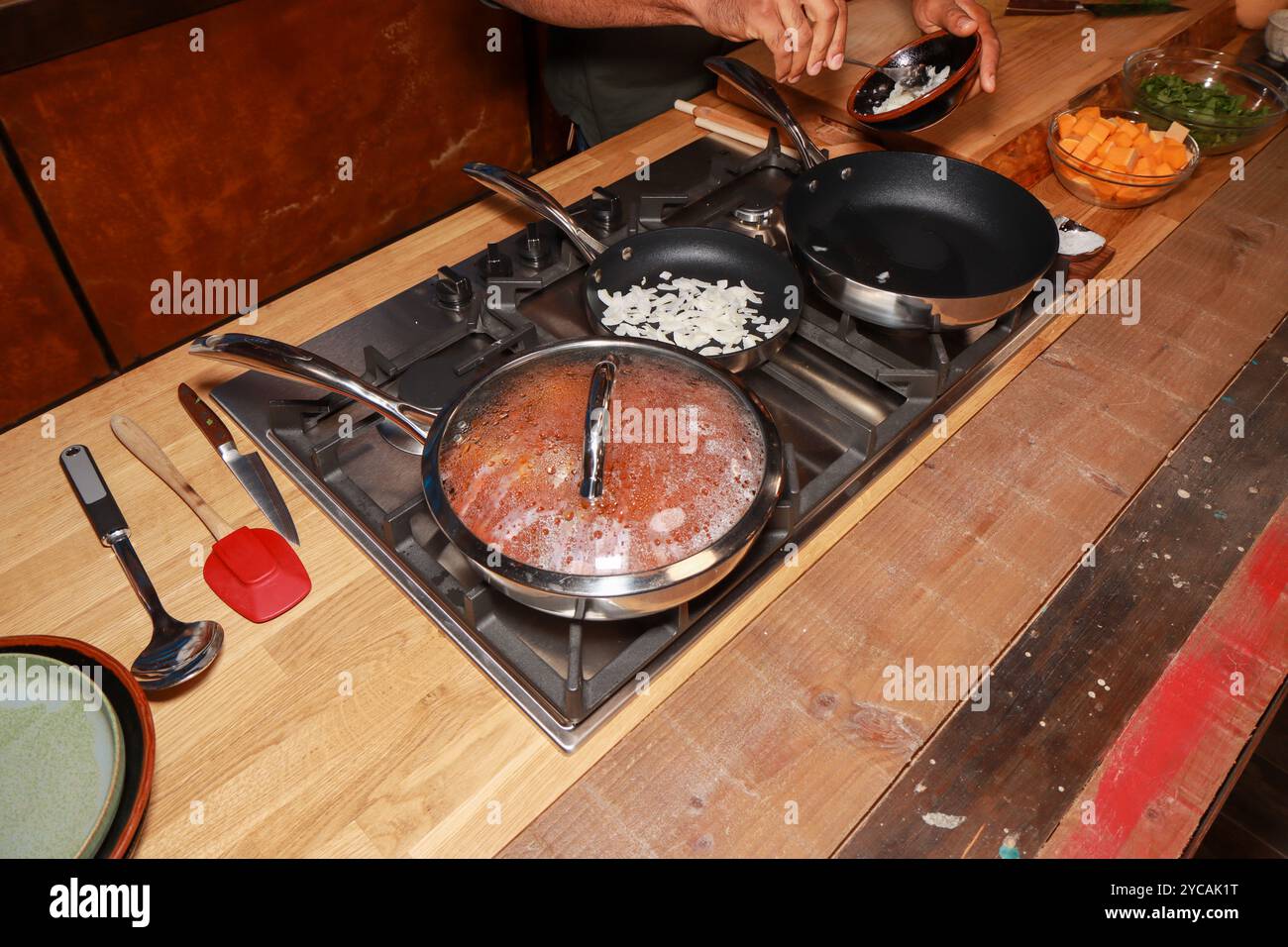 Silver pans cooking on a gas stove showing the steam boiling in the ...