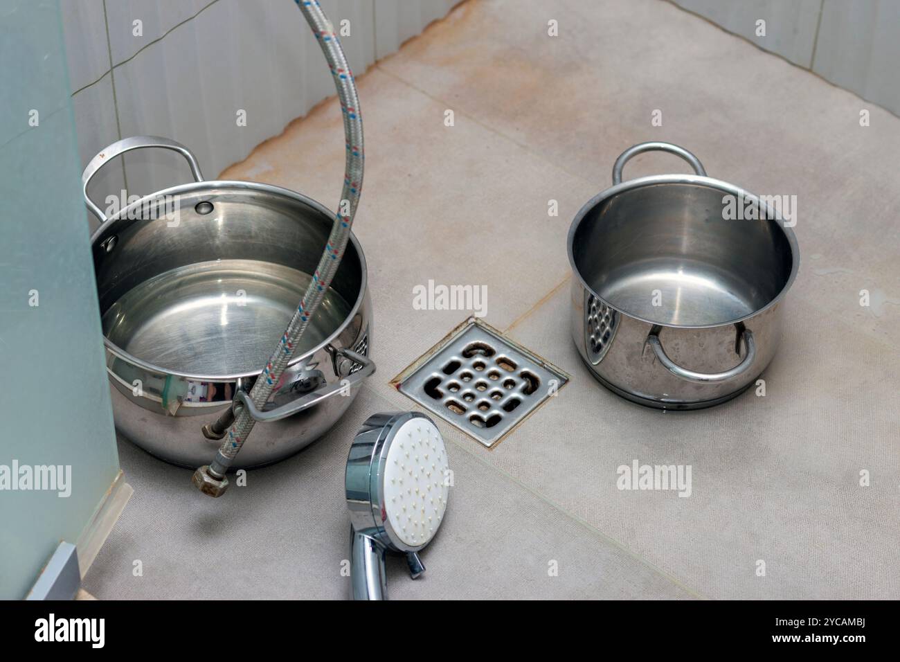 casseroles with water on the shower tiled floor, indoor shot, no people ...