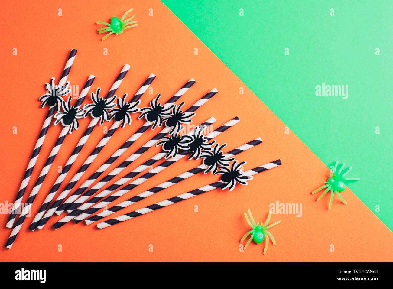 Drinking straws with spiders for Halloween celebration on orange and ...