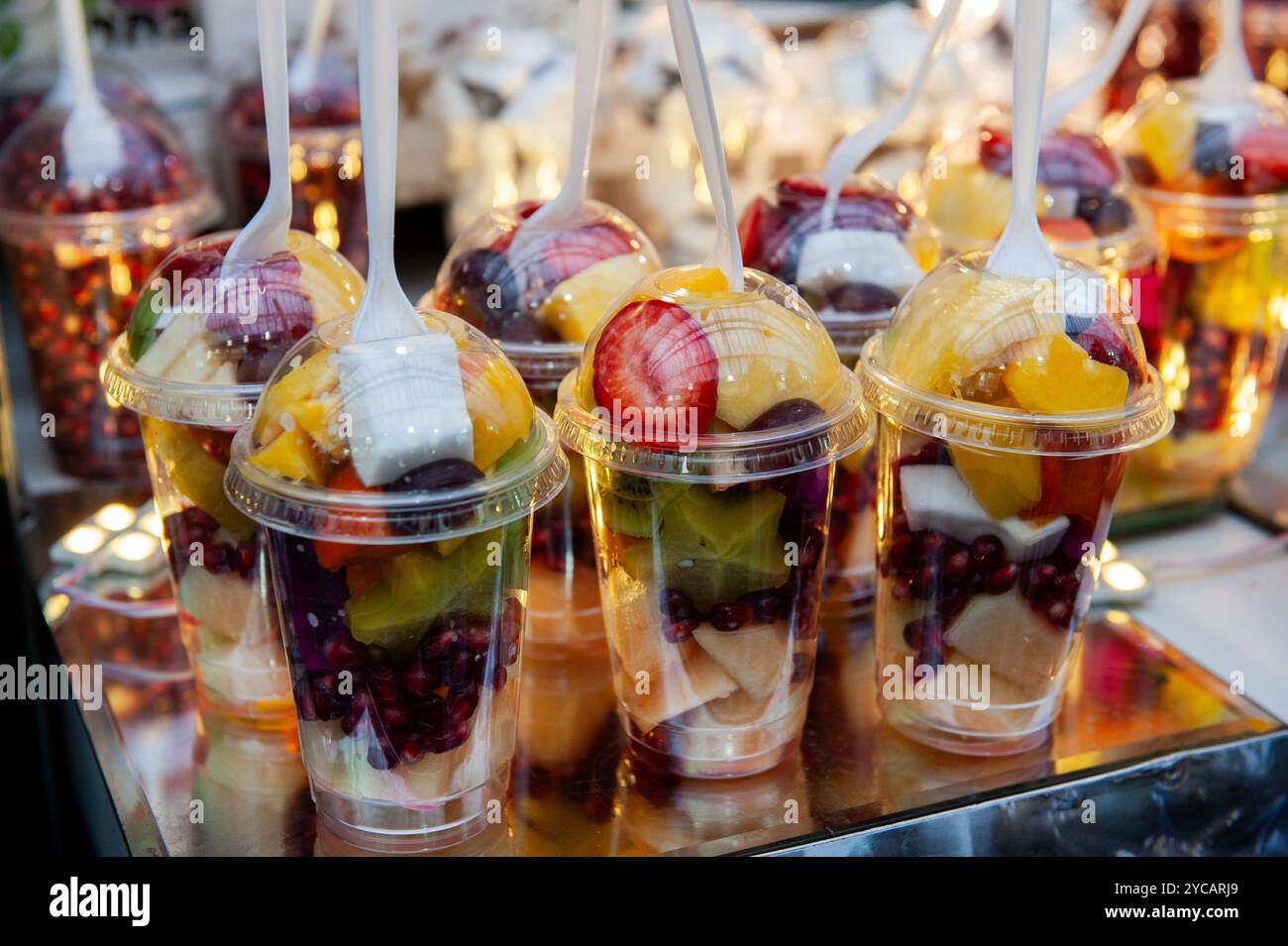 Plastic spoons and cups filled with a mixture of freshly-cut fruits for ...