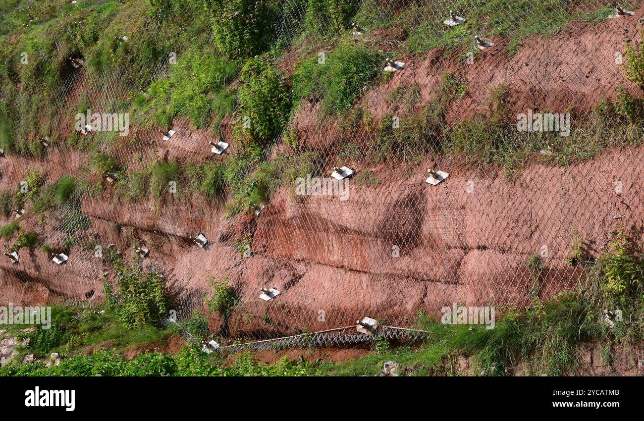 Rock bolts and wire netting supporting unstable red sandstone cliffs ...