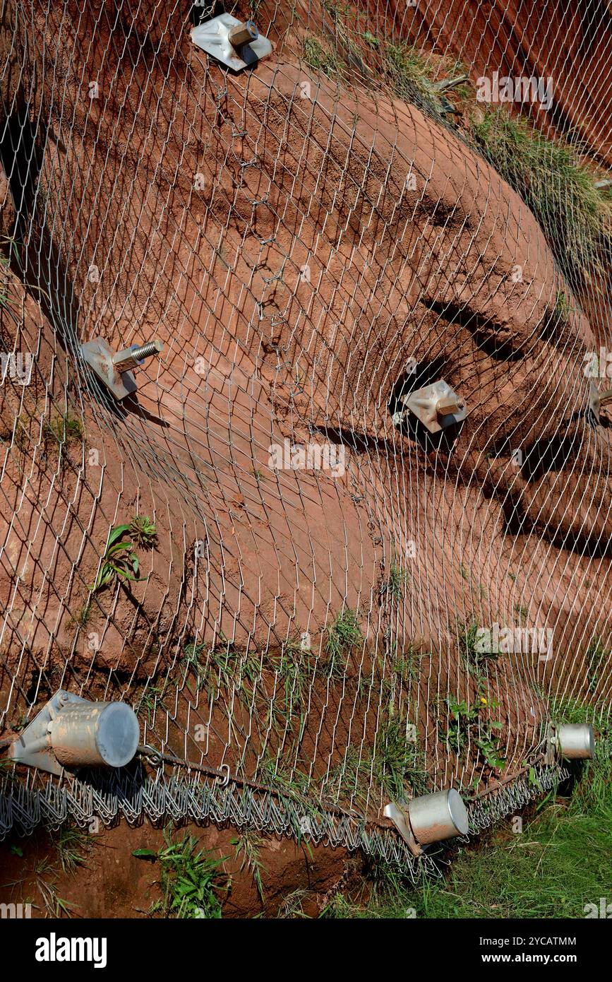 Rock bolts and wire netting supporting unstable red sandstone cliffs ...