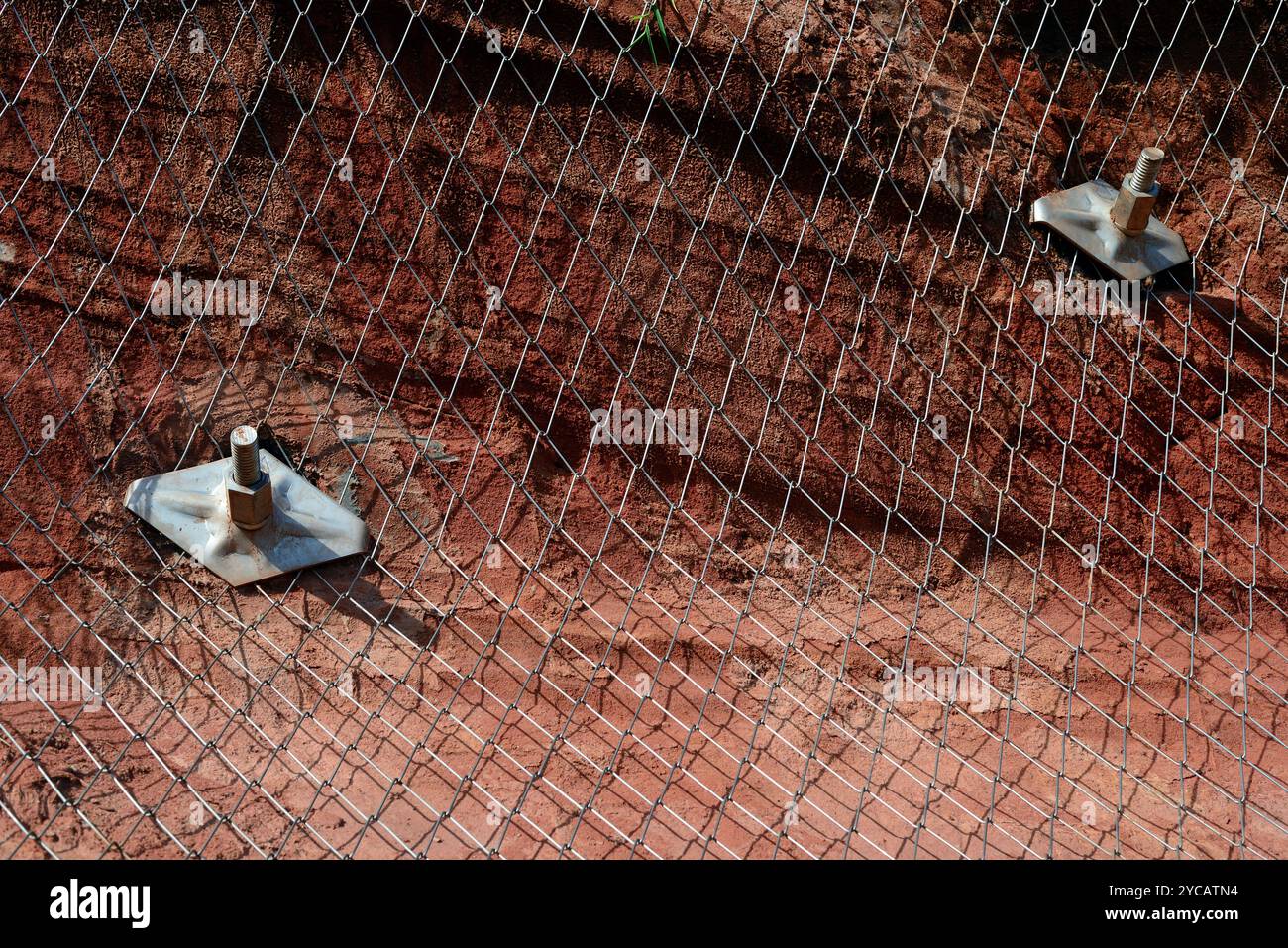 Rock bolts and wire netting supporting unstable red sandstone cliffs ...