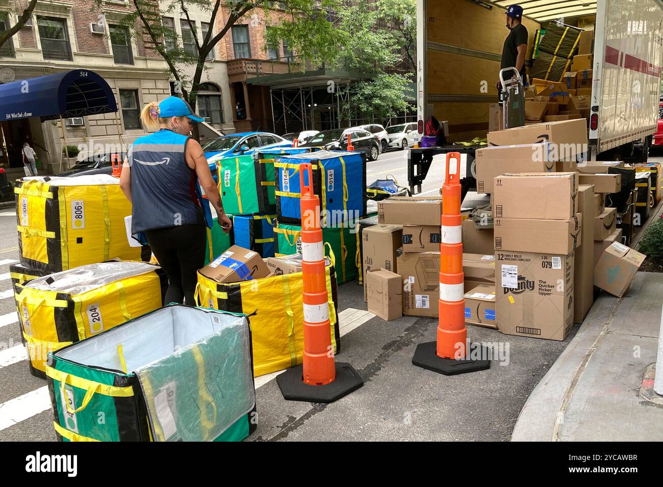 FILE - An Amazon worker sorts deliveries on a street corner on New York ...