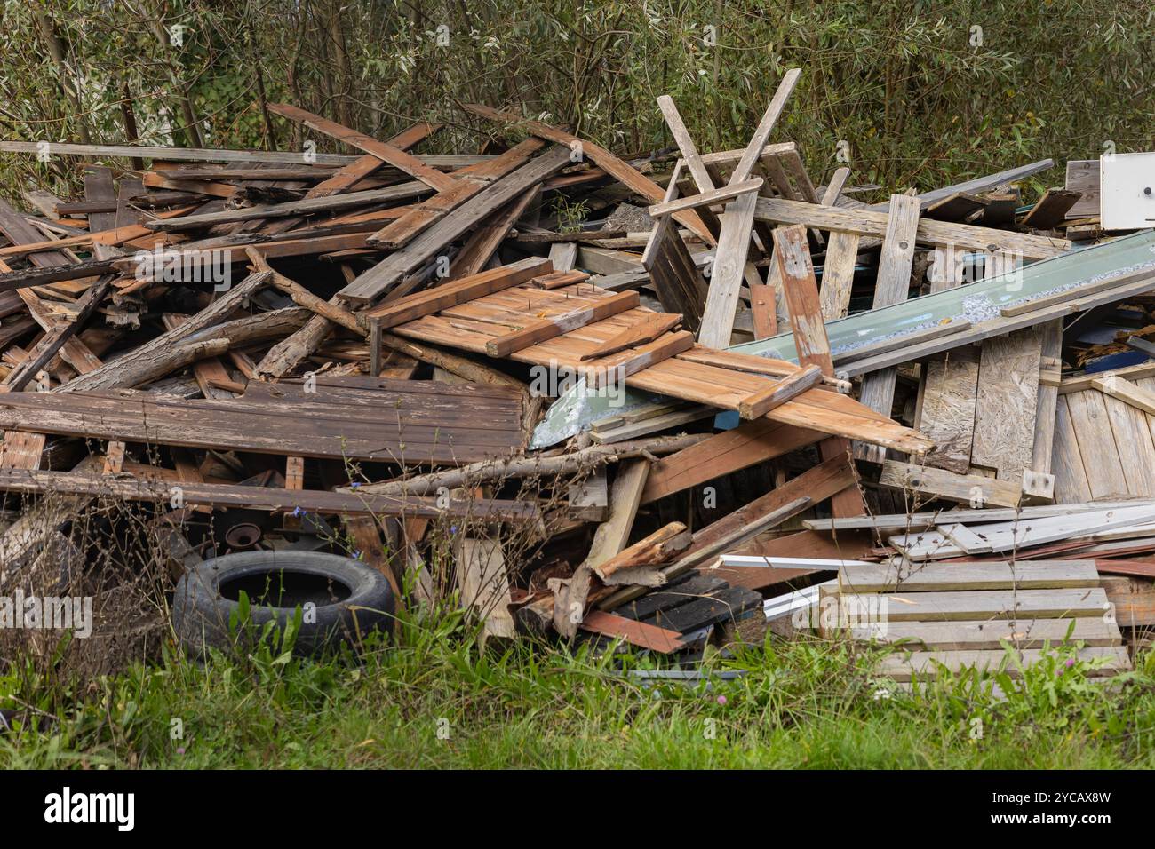 Pile of wooden debris and scrap materials in a rural outdoor area ...
