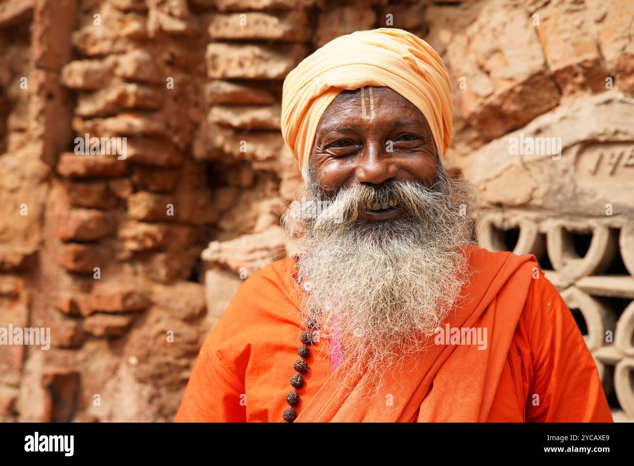 A sadhu poses before a dialopted terracotta mandir of Baidyapur. East ...
